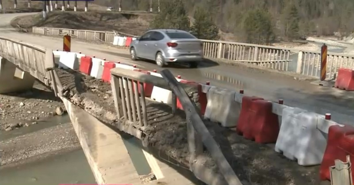 VIDEO Pod de pe un drum național, proptit în prăjini de lemn ca să nu ...